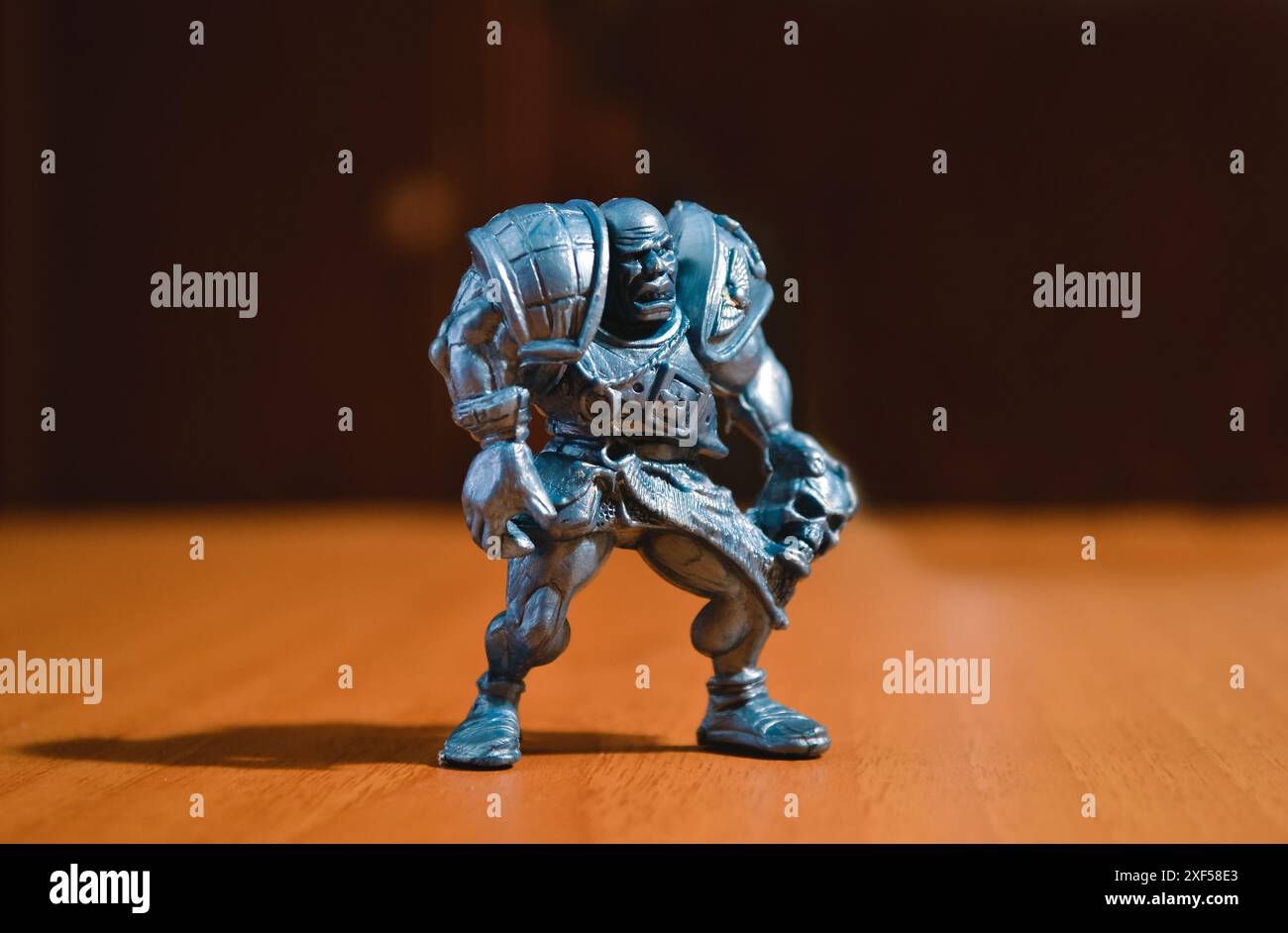 A figurine of an aggressive and vicious bald warrior in armor with a ...