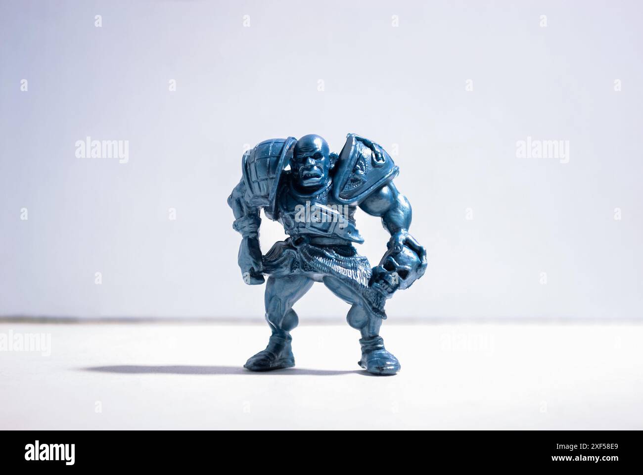 A figurine of an aggressive and vicious bald warrior in armor with a ...