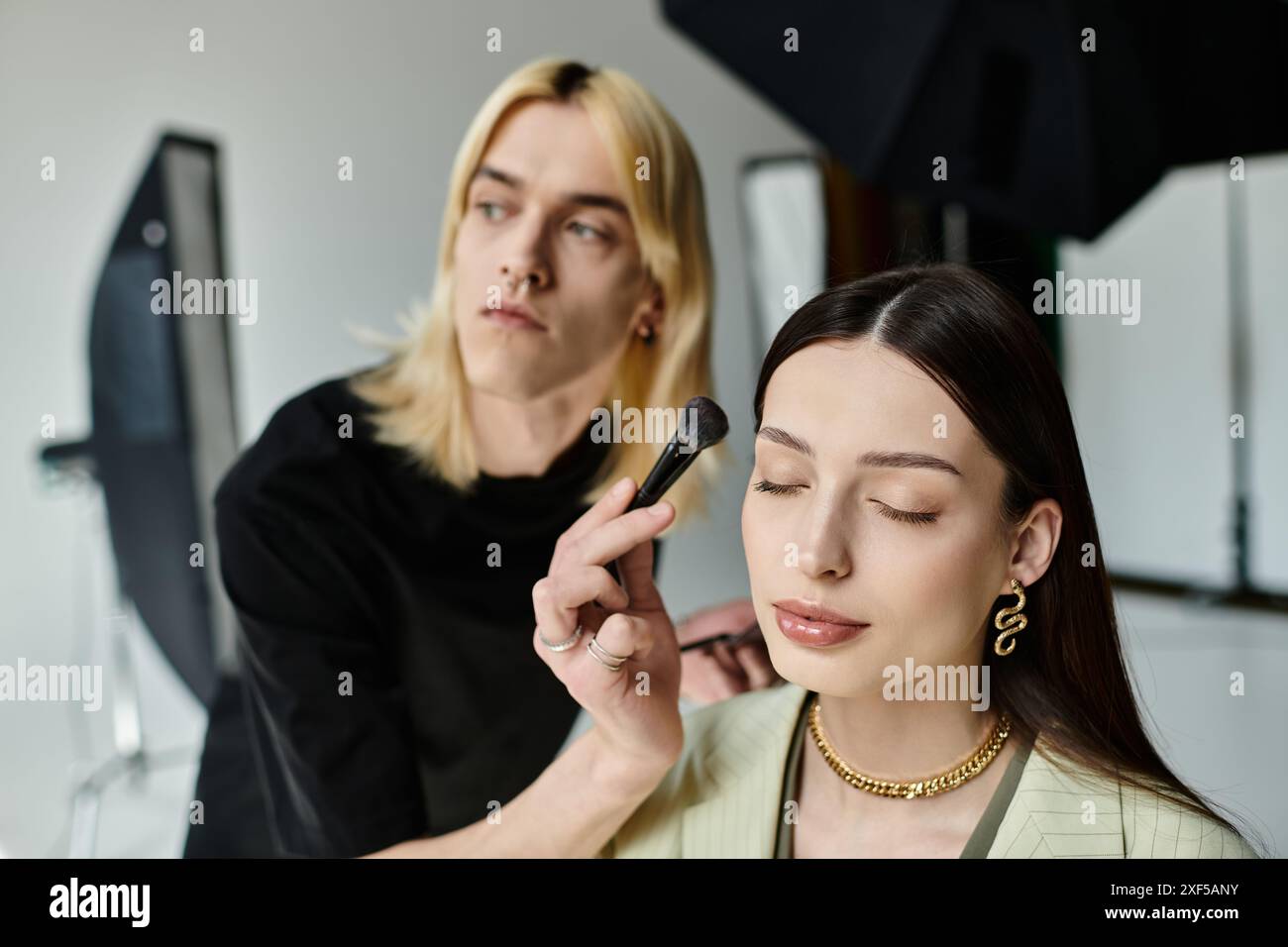 Professional makeup artist applies makeup on a womans face, enhancing ...