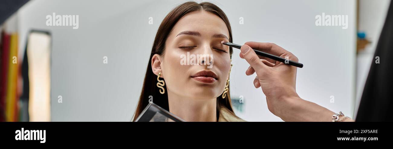 A professional makeup artist applying makeup on a womans face Stock ...