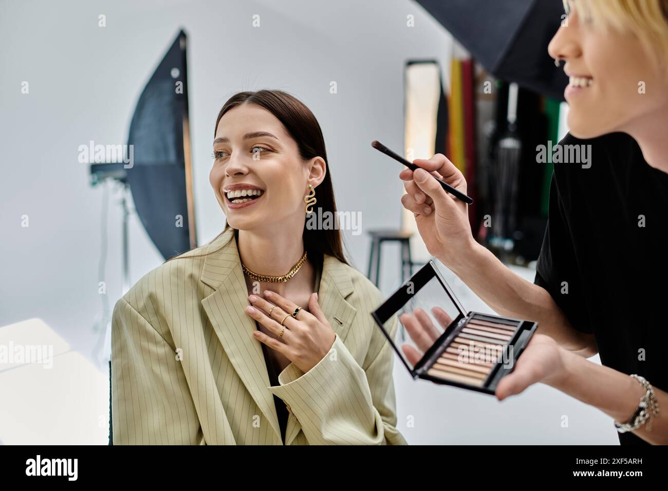 Professional makeup artist applying makeup to a womans face Stock Photo ...