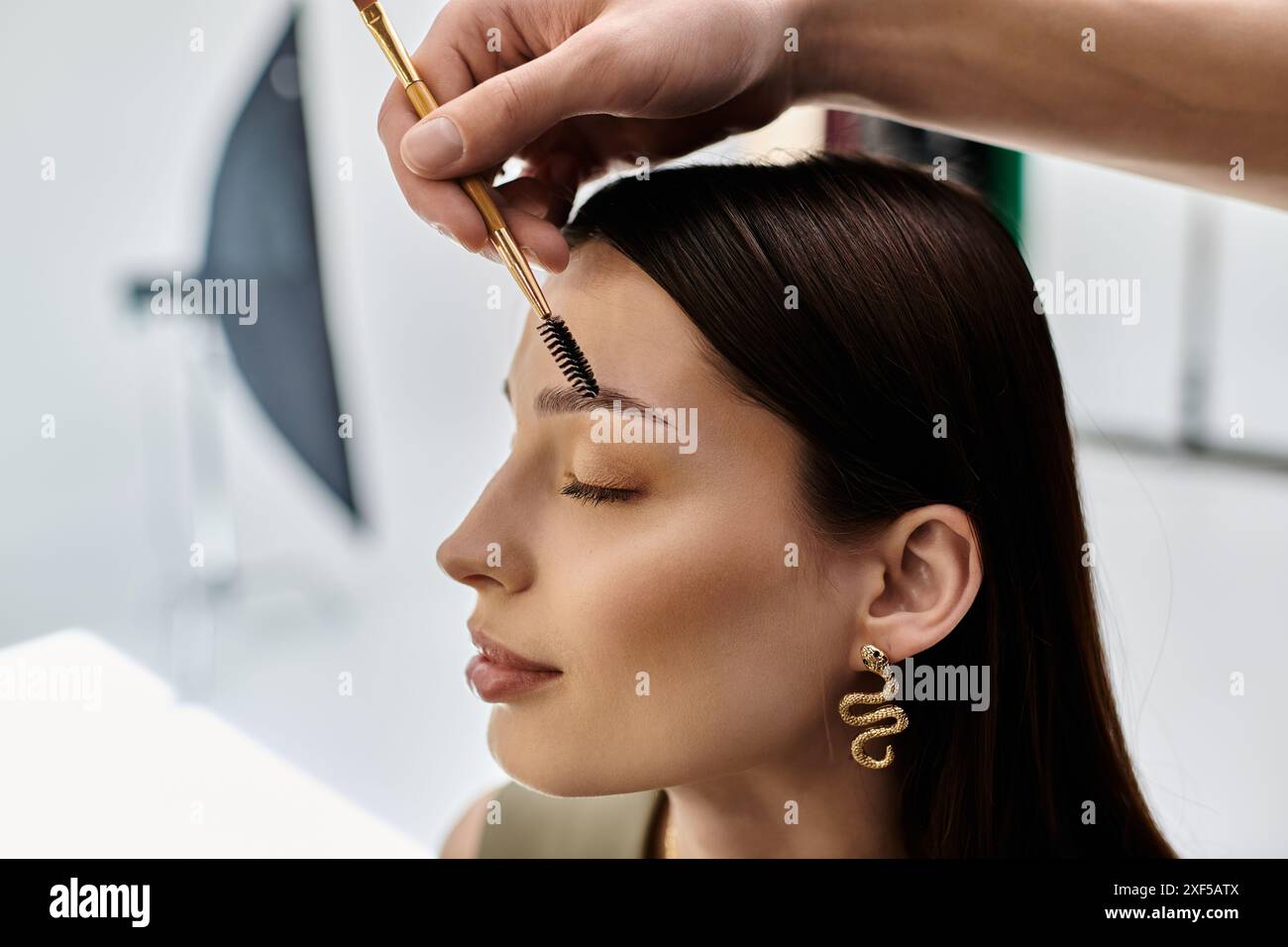 Merry woman enjoying makeup session with stylist Stock Photo - Alamy