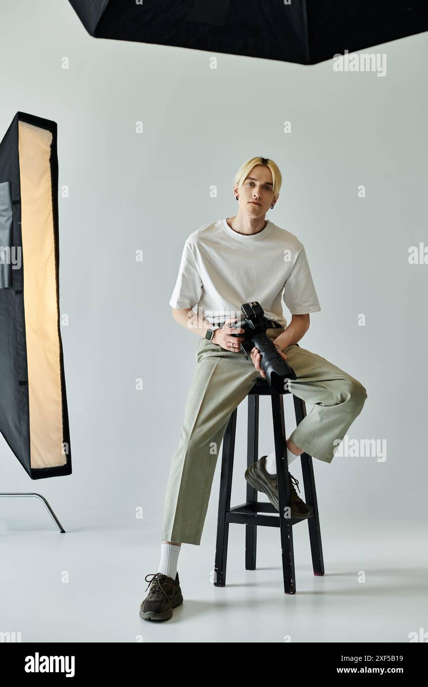 A stylish man sits on a stool, capturing images with a camera Stock ...