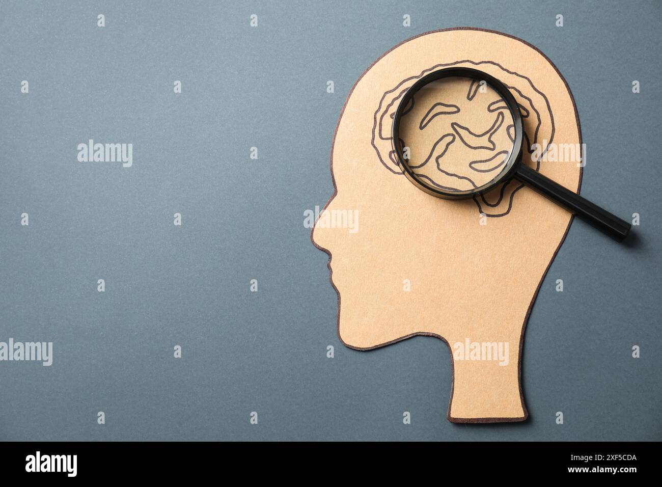 Amnesia. Human head cutout with drawing of brain and magnifying glass ...