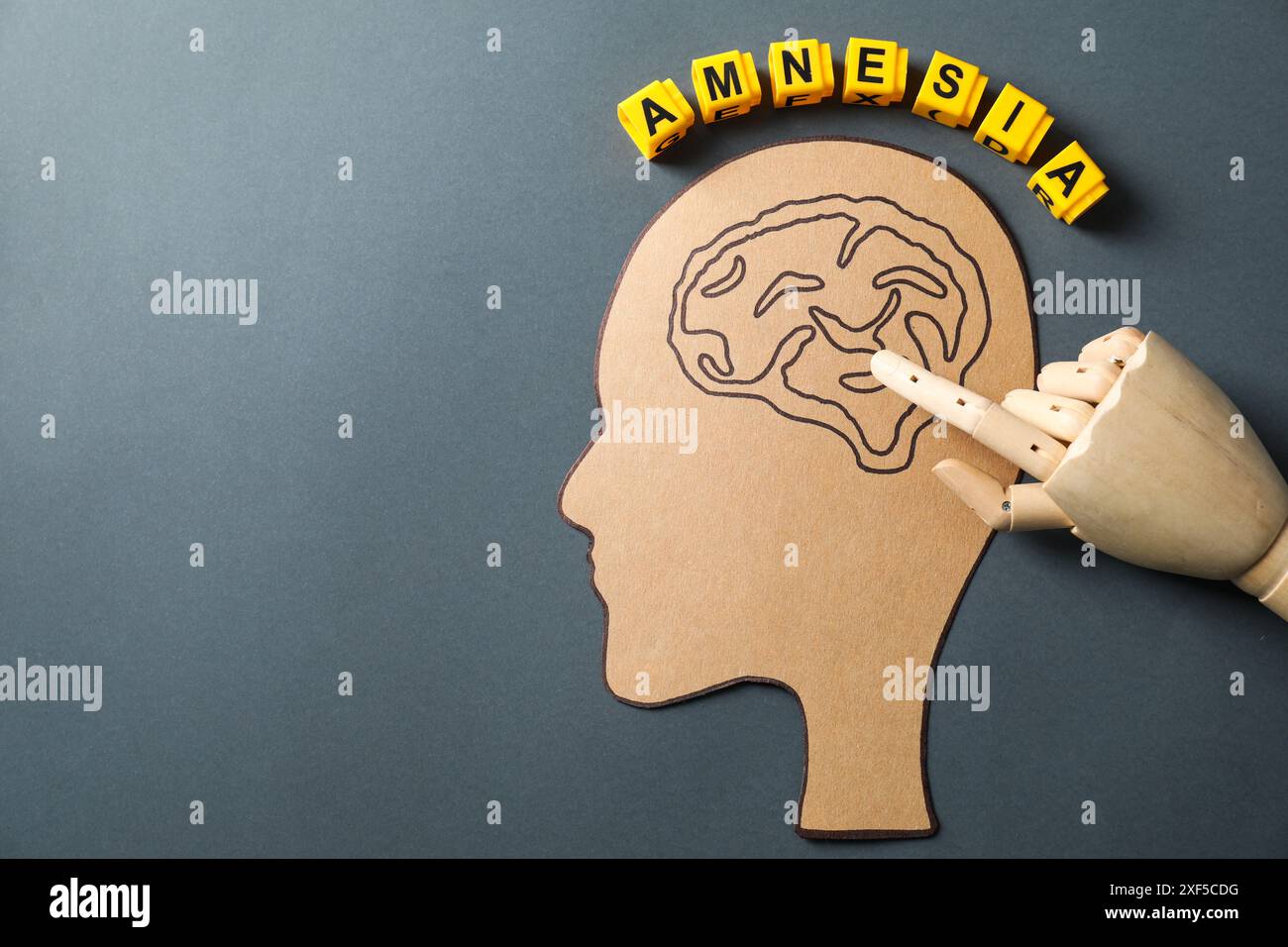 Yellow cubes with word Amnesia and mannequin hand pointing at drawing ...