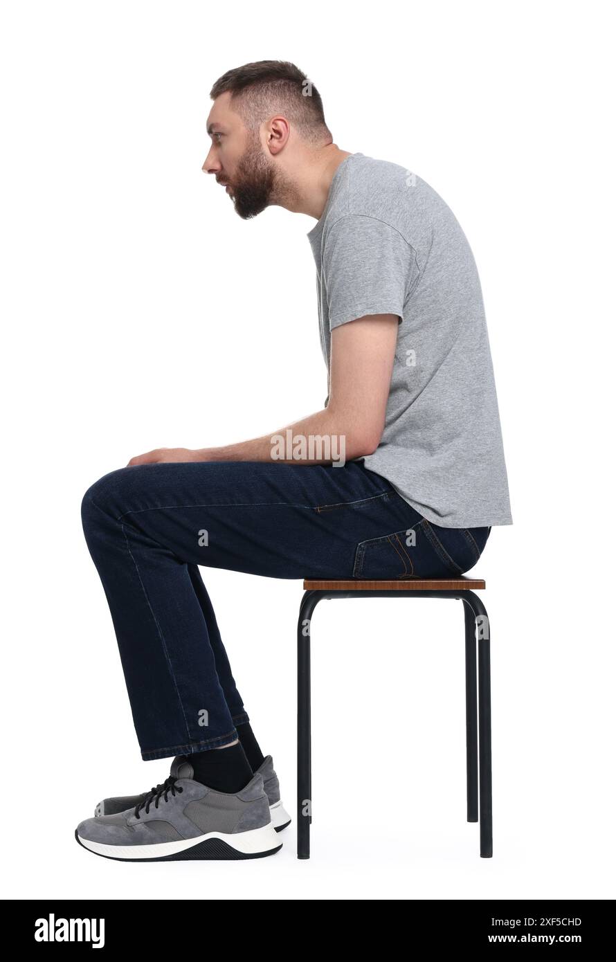 Man with poor posture sitting on chair against white background Stock ...