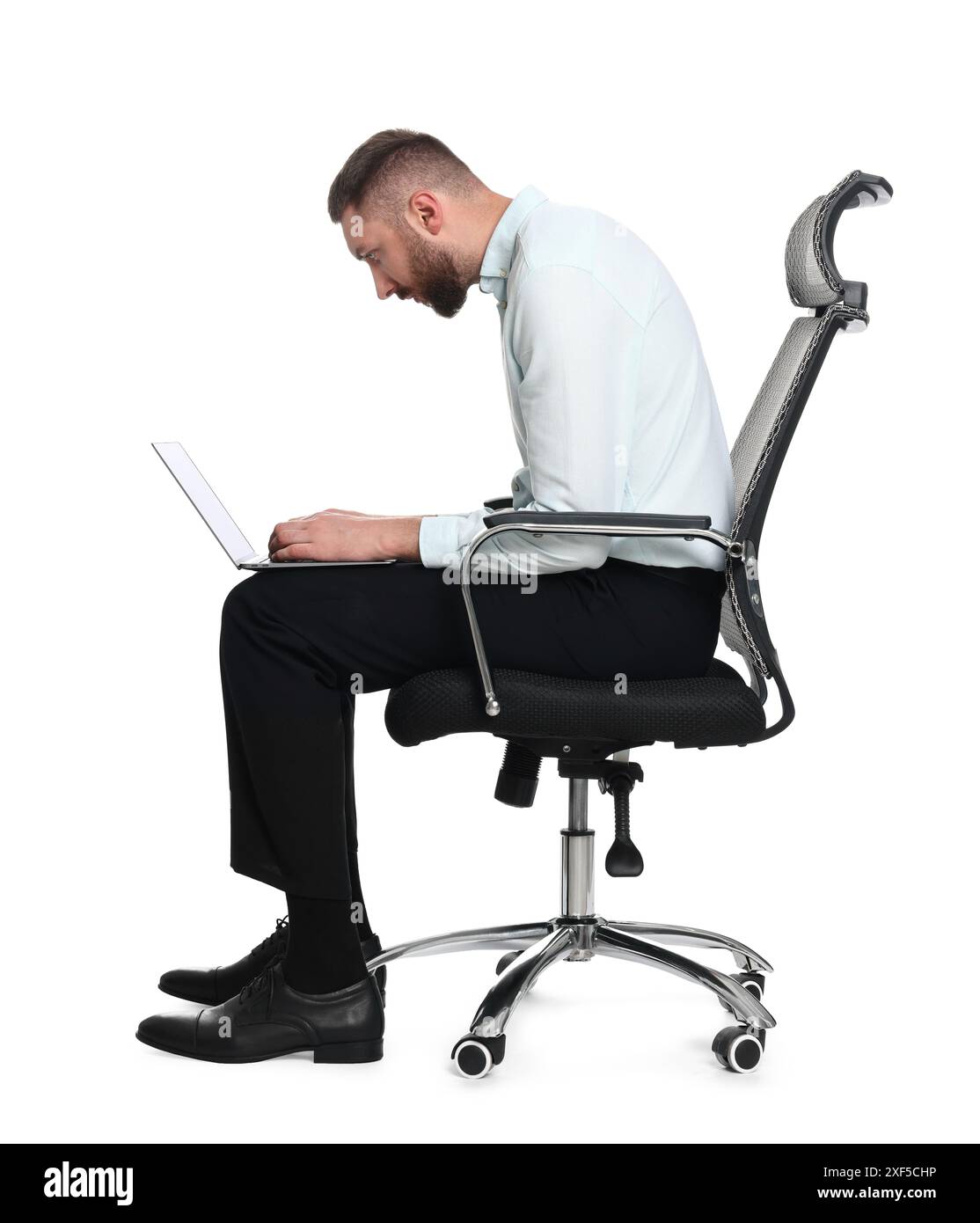 Man with poor posture sitting on chair and using laptop against white ...