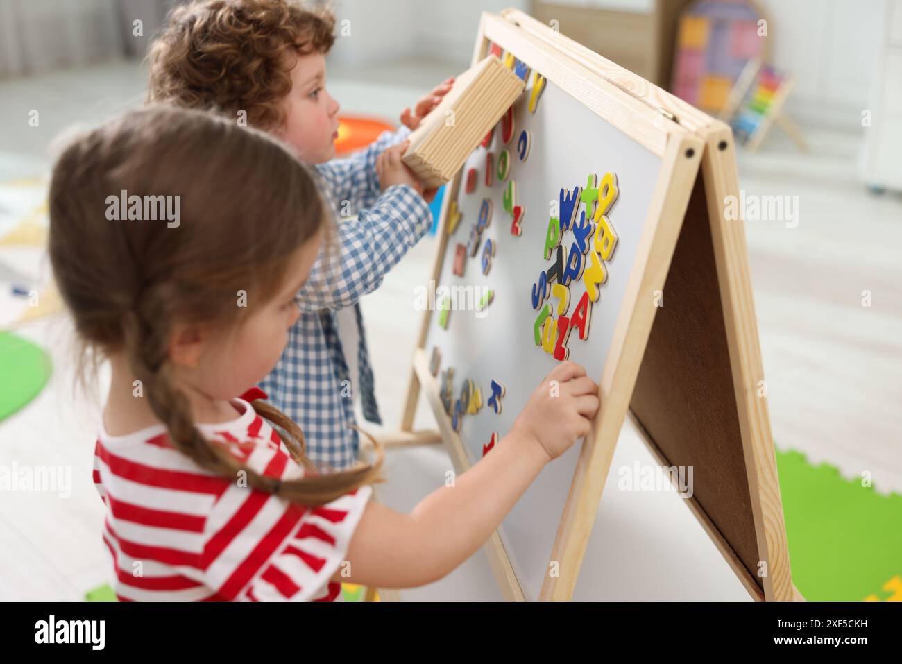 Little children learning alphabet with magnetic letters on board in ...