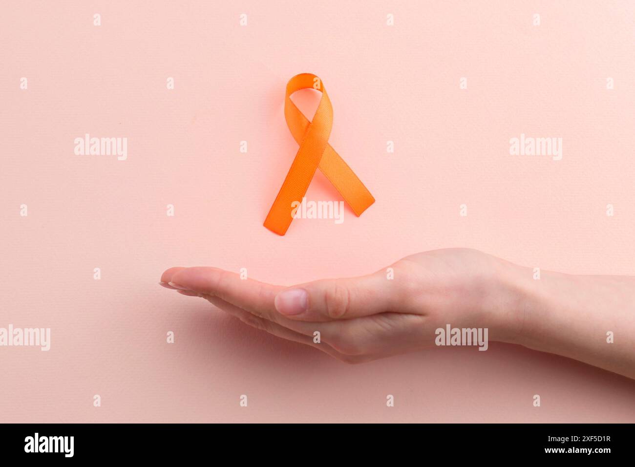 Woman with orange awareness ribbon on beige background, top view Stock ...