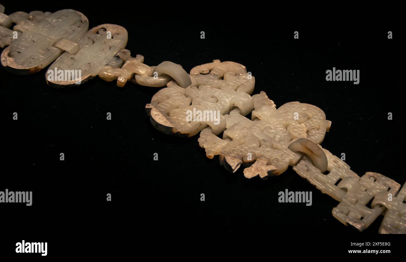 A Chinese jade artifact with exquisite patterns against black ...