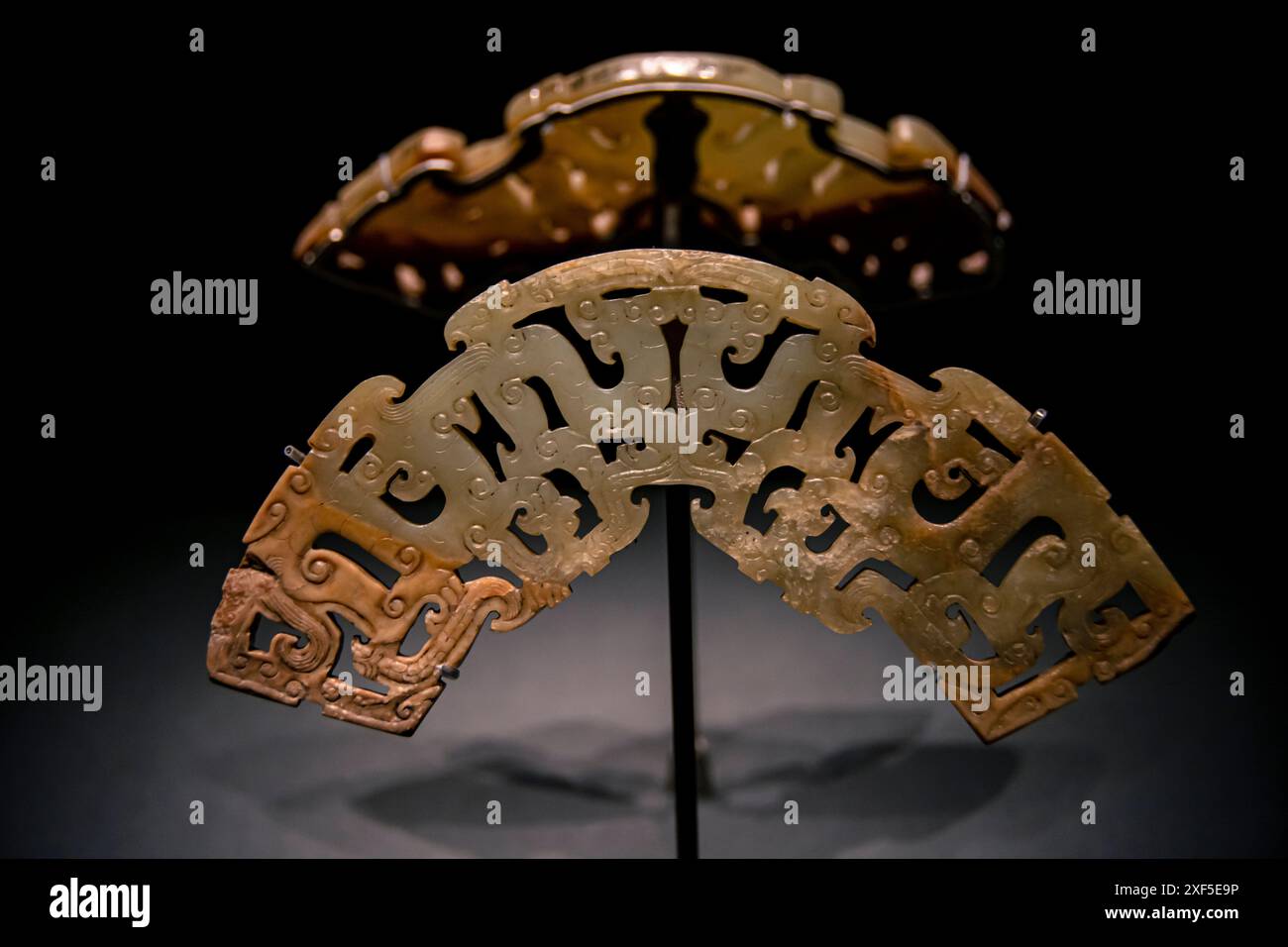 A Chinese jade artifact with exquisite patterns against dark background ...