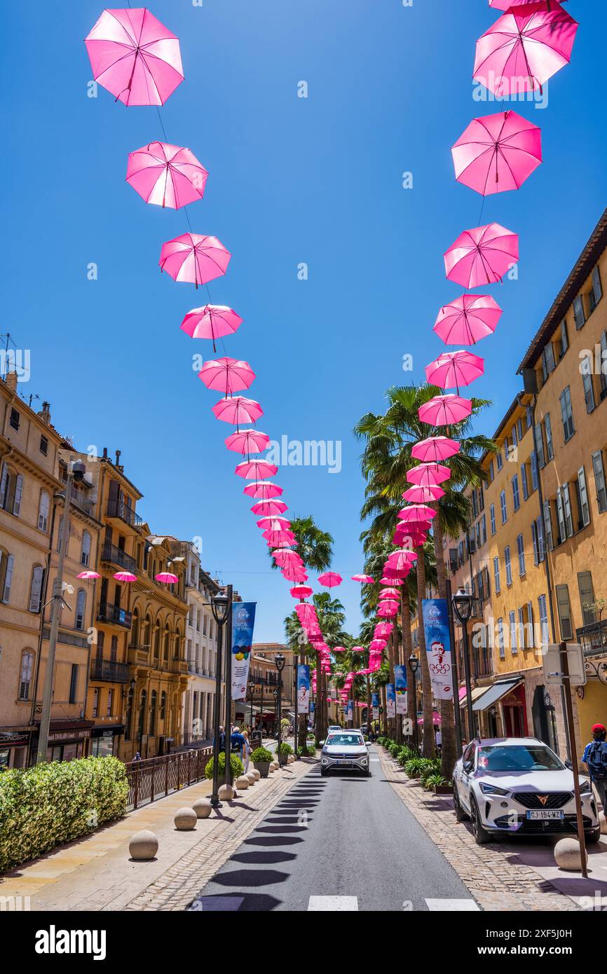 Street lined with floating pink umbrellas in old town of Grasse on the ...