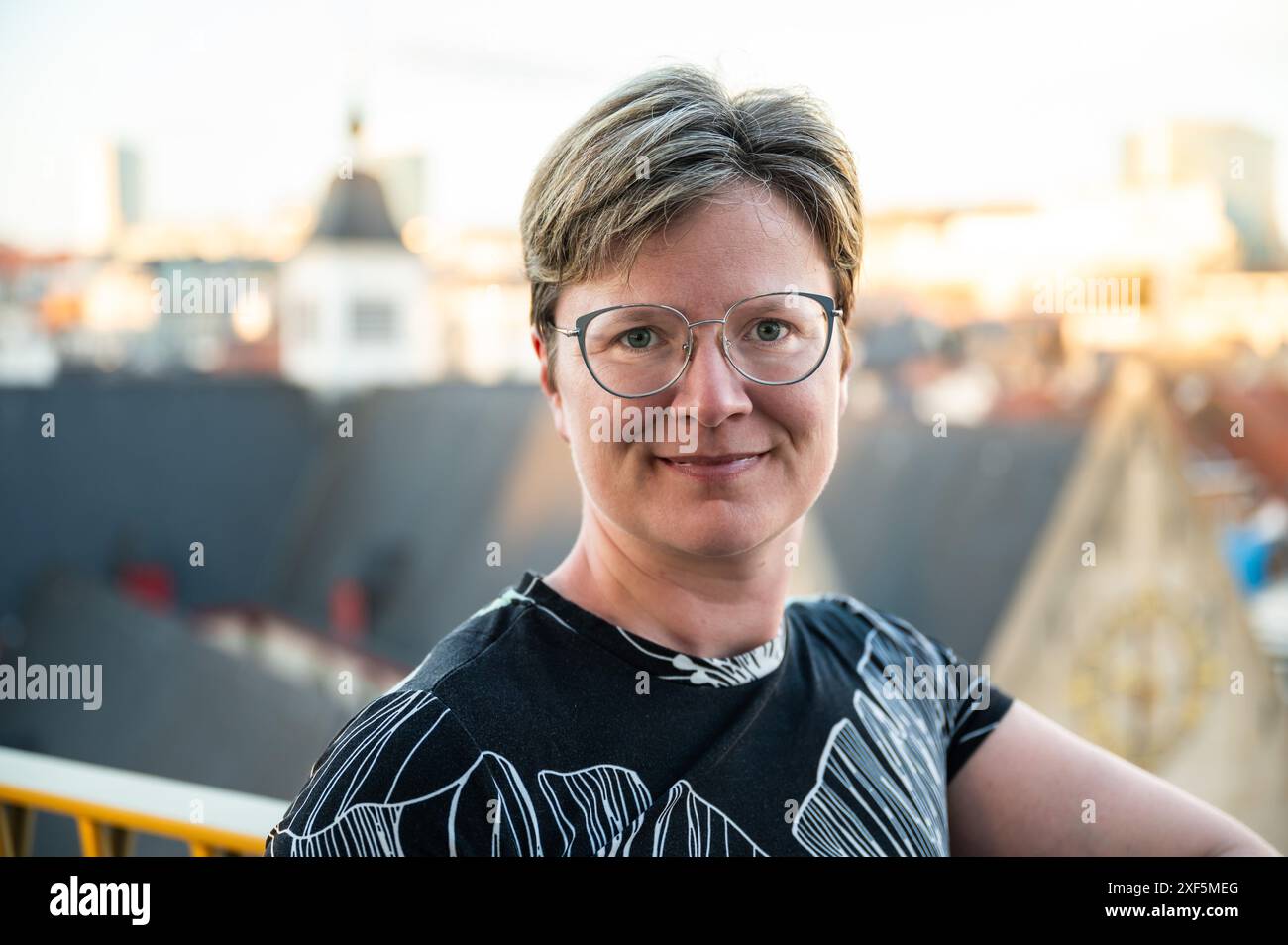 Outdoor portrait of a 38 yo white woman on a rooftop with old town in ...