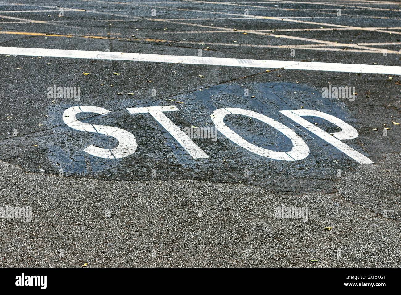 Stop sign painted on the asphalt of the parking lot in the city. The ...