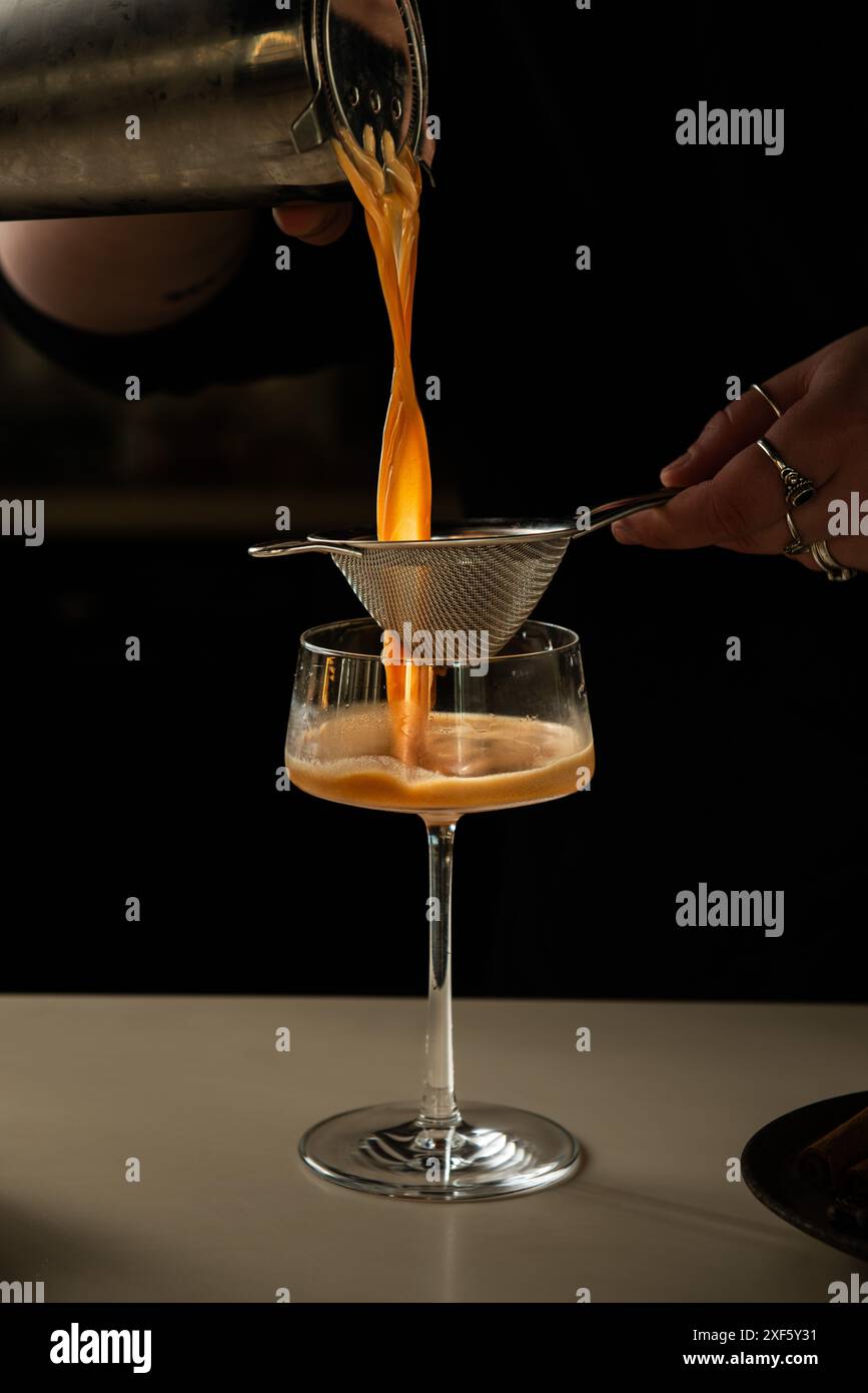 Barista pouring iced coffee from jug to glass. Hands only Stock Photo ...