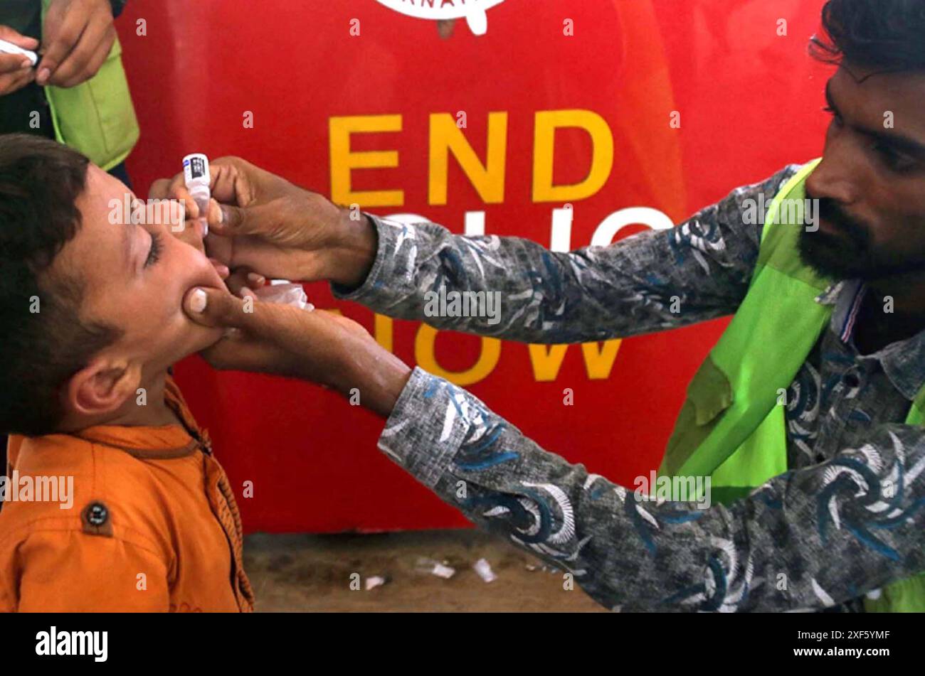 Health worker administrates polio-vaccine drops to a child during anti ...