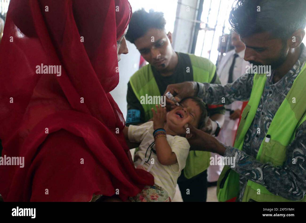 Health worker administrates polio-vaccine drops to a child during anti ...