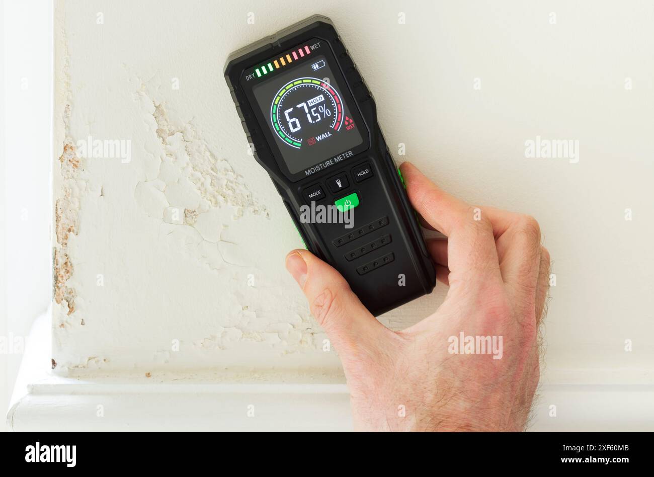 Moisture detector (moisture testing meter) against a wall with rising ...