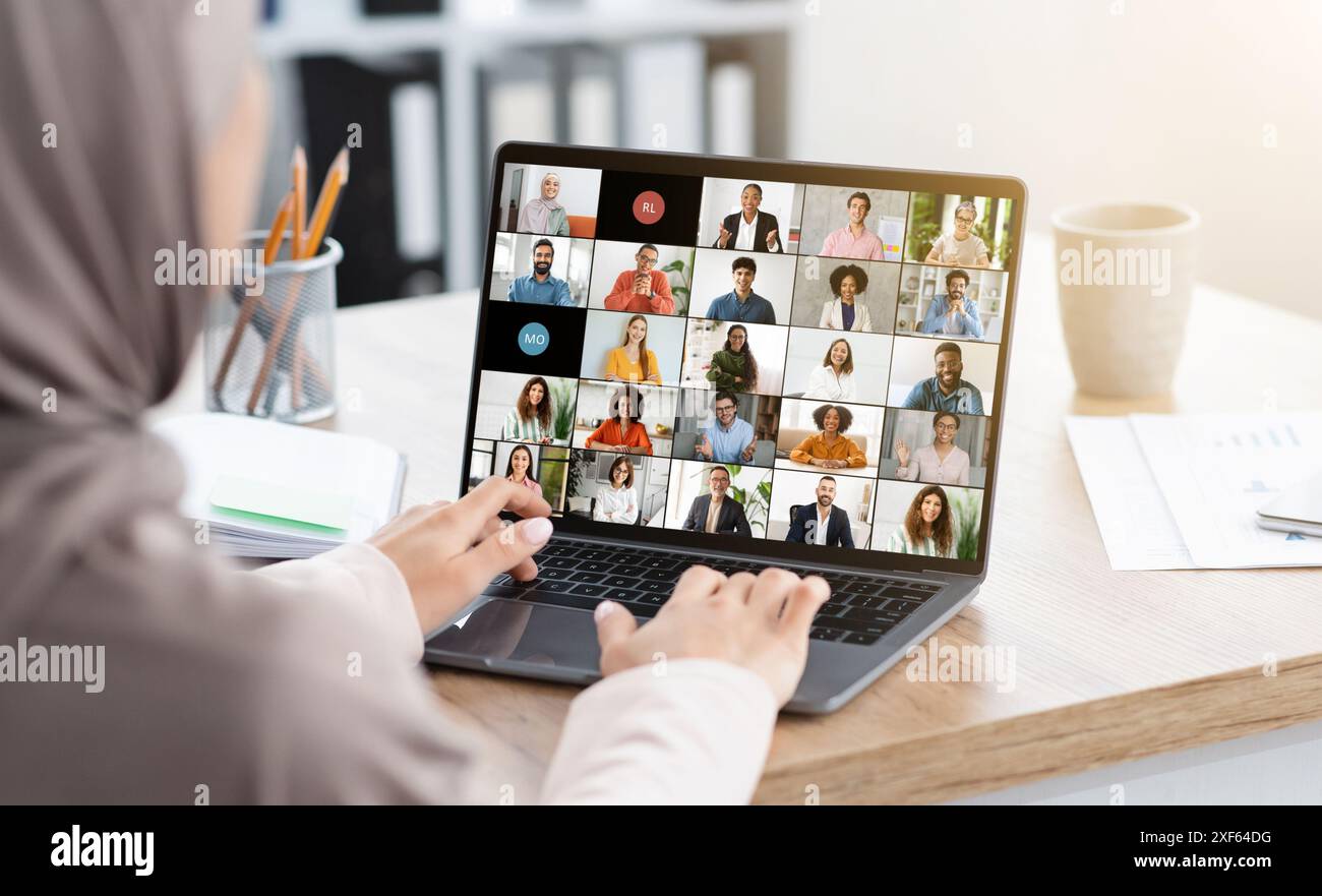 Muslim Woman Participating in a Large Virtual Meeting on Laptop Stock ...