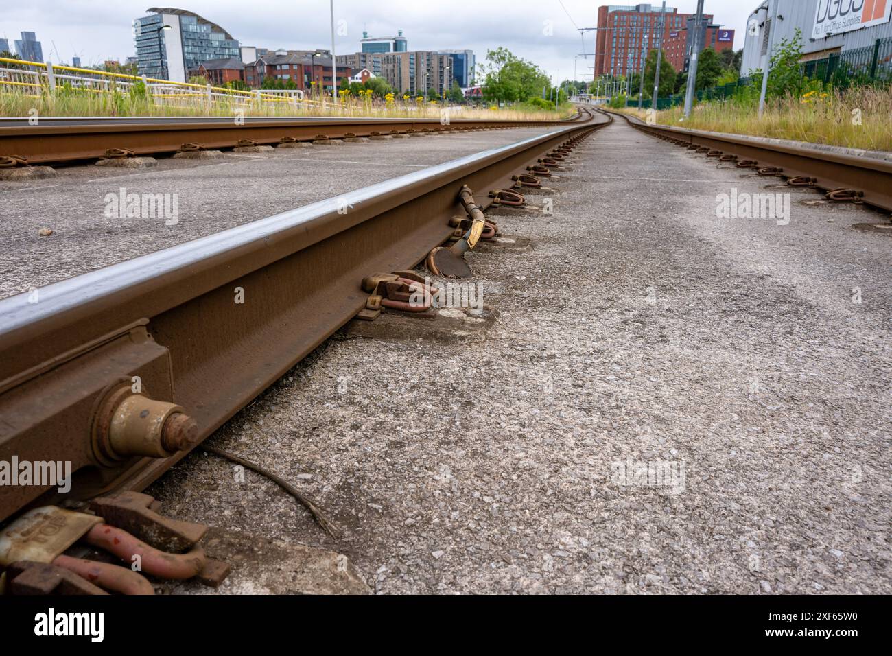 A single railway track stretching into the distance with urban ...