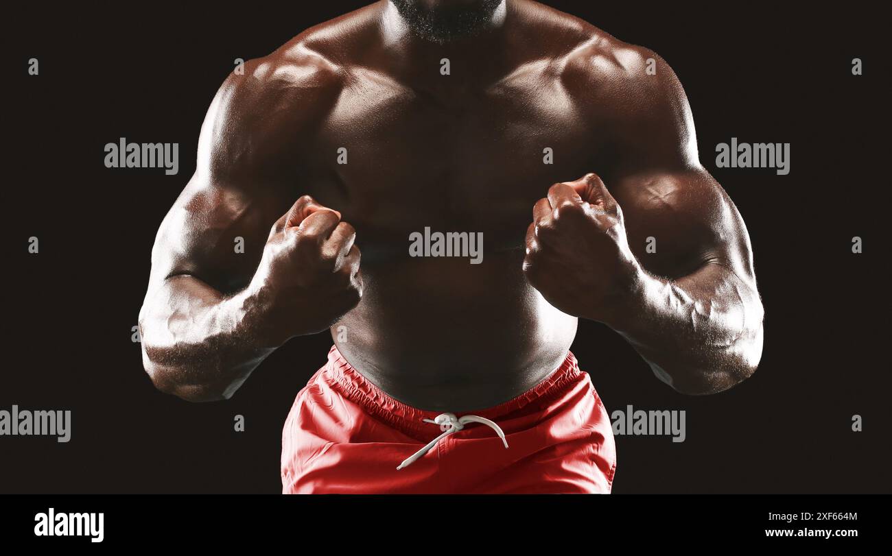 Muscular Man Flexing Biceps Against Black Background Stock Photo - Alamy