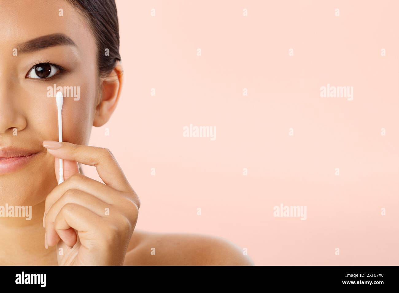 Woman Applying Cotton Swab to Face Skin in Studio Setting Stock Photo ...