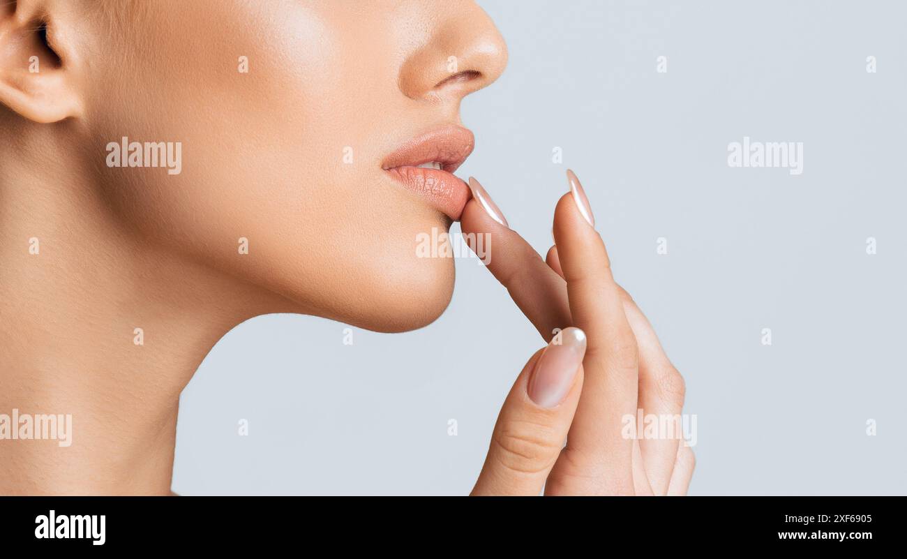 Woman Touching Her Lips With Finger in Profile Stock Photo - Alamy