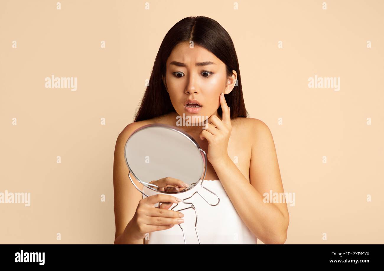 Woman Looking at Skin Imperfections in Mirror Stock Photo - Alamy