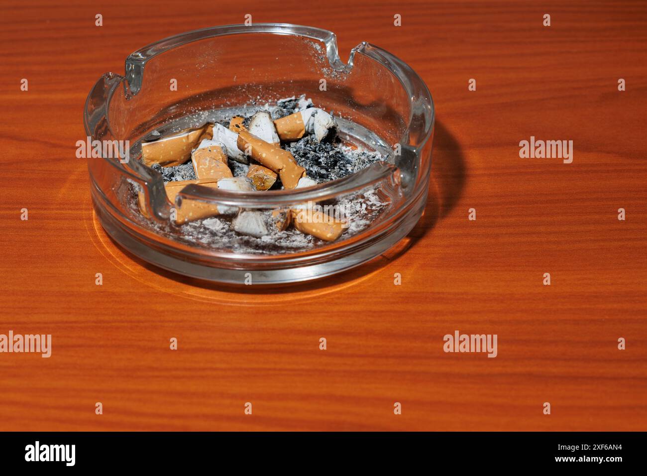 Glass ashtray with cigarette butts on table and negative space Stock ...