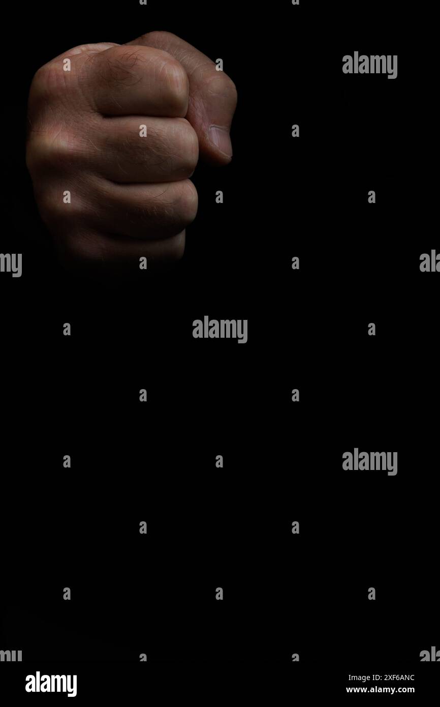 Vertical photo with clenched fist and black background Stock Photo - Alamy