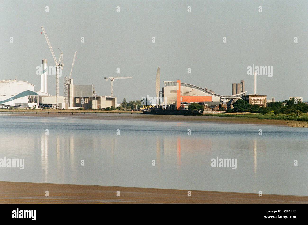 Industrial buildings and cranes on the south bank of the Thames Estuary ...