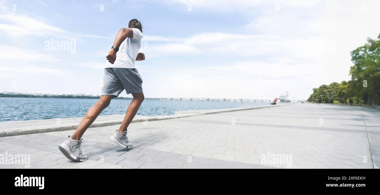 Afro Man Jogging Along River Bank In City. Panorama, Rear View Stock ...