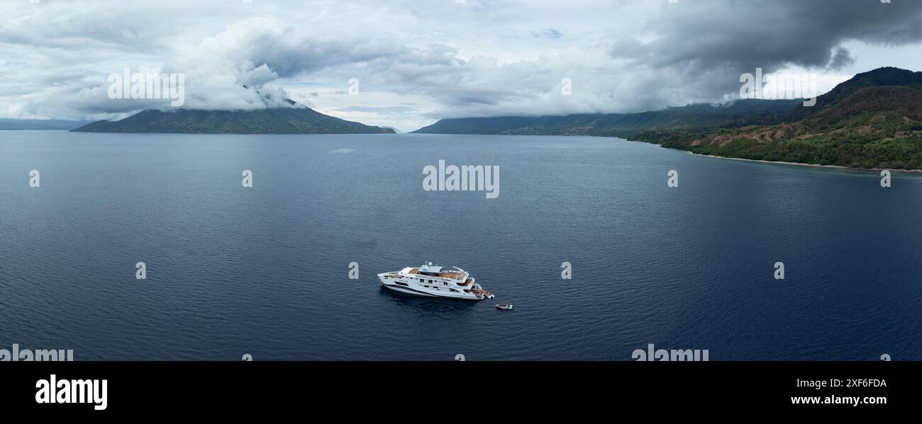 A liveaboard dive boat sits at anchor in the beautiful Pantar Strait ...