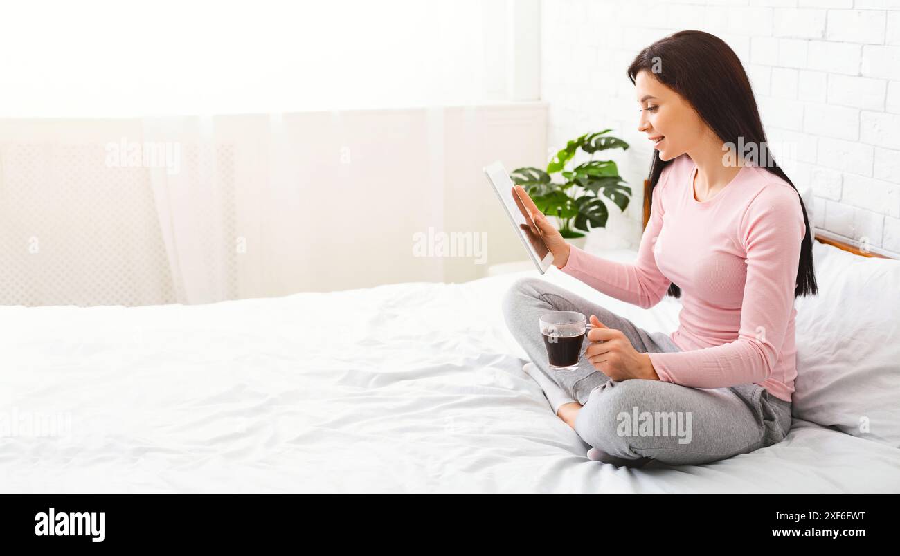 Young Woman Enjoying Morning With Coffee and Tablet on Bed Stock Photo ...