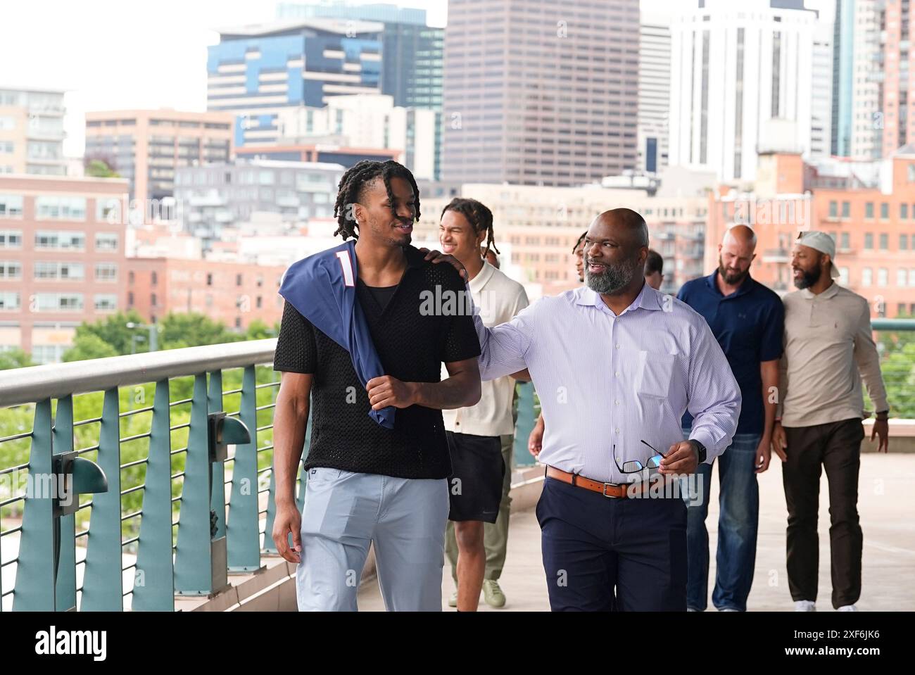 Denver Nuggets 2024 first-round draft pick DeRon Holmes II, left, walks ...
