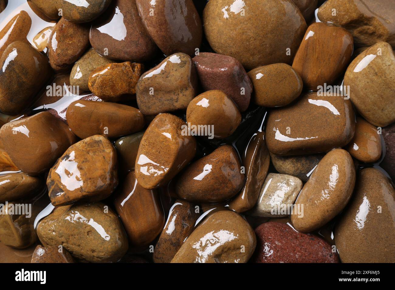 Beautiful pebbles in water as background, top view Stock Photo - Alamy