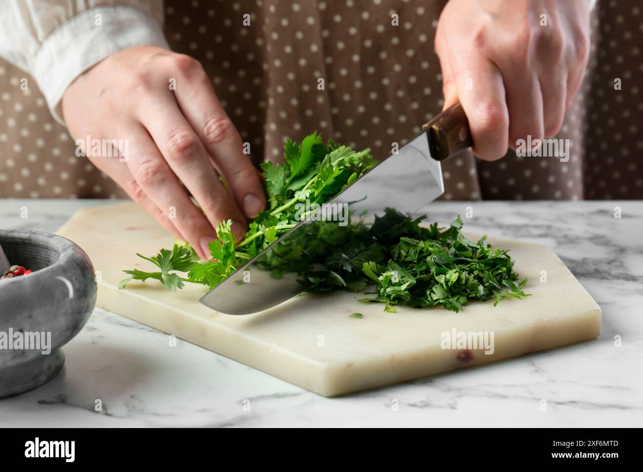Woman cutting fresh coriander at white marble table, closeup Stock ...