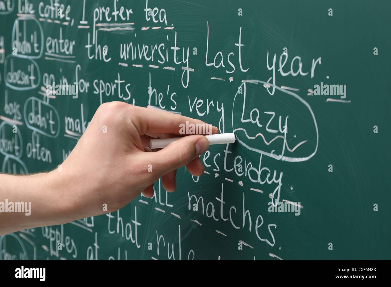 English teacher writing with chalk on green chalkboard, closeup Stock ...