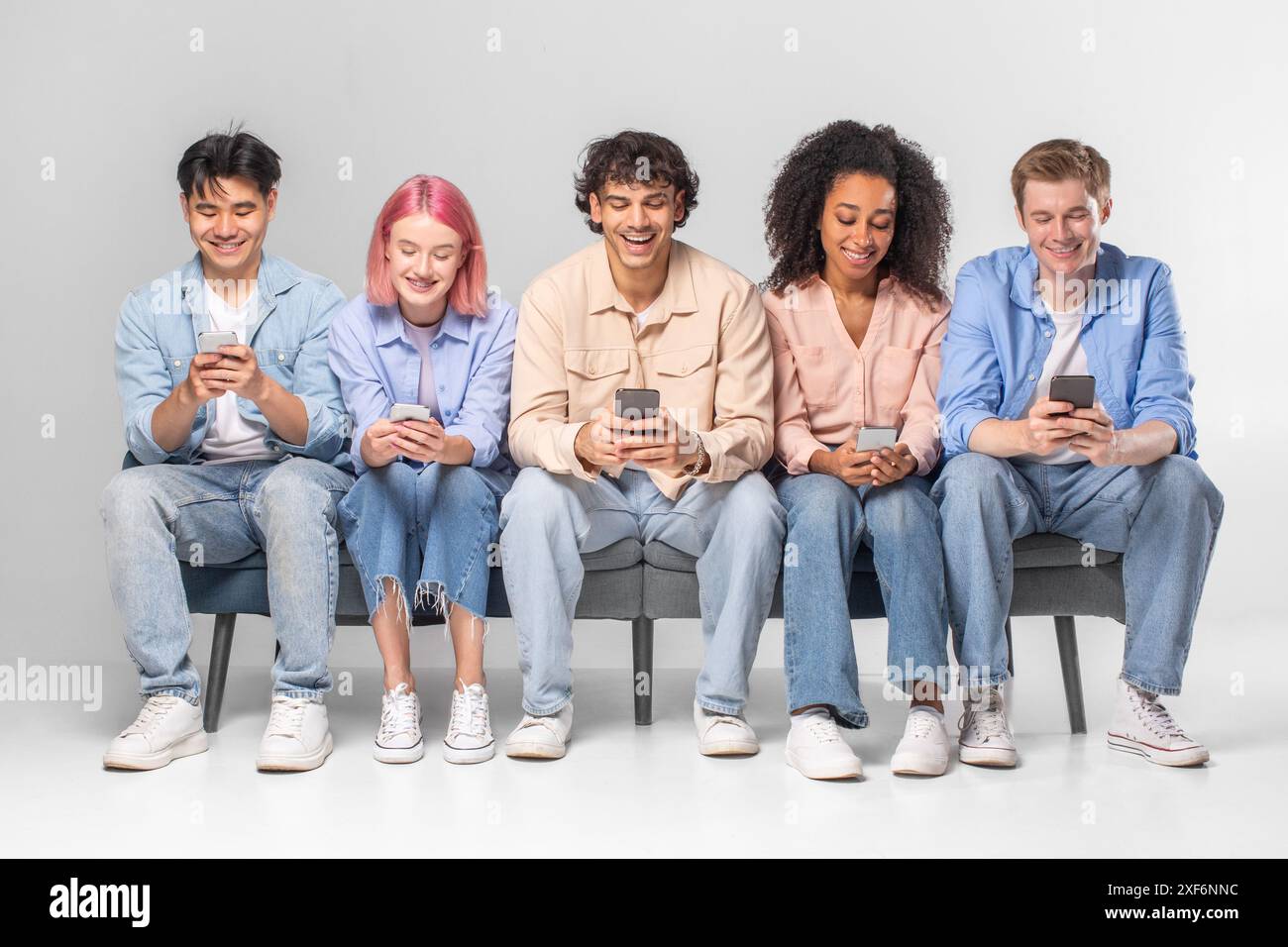 Five Diverse Young Adults Use Smartphones While Sitting on Bench Stock ...