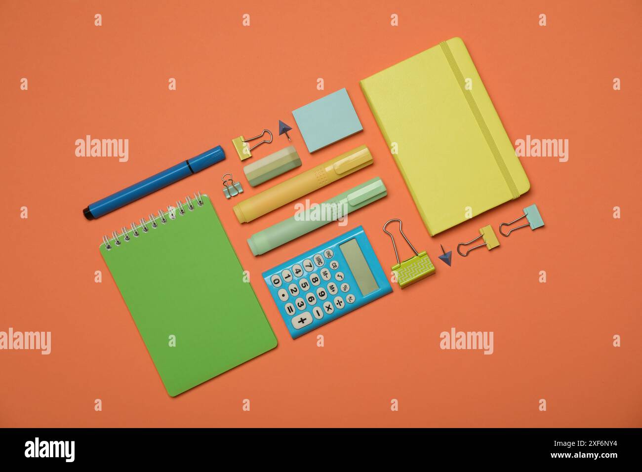 Flat lay composition with notebooks and different stationery on orange ...
