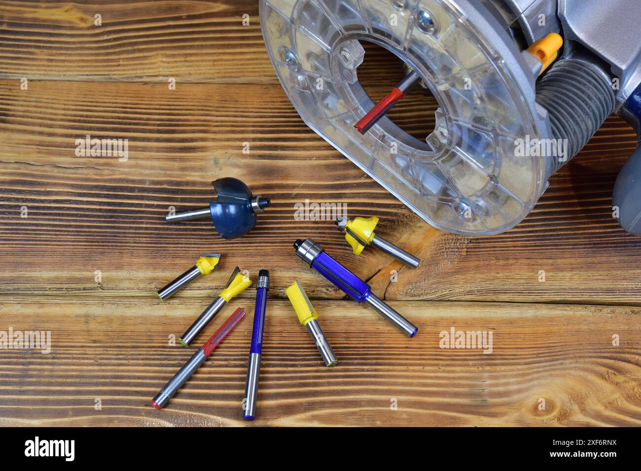 Wood router base and various shape cutter bit on wood board background ...