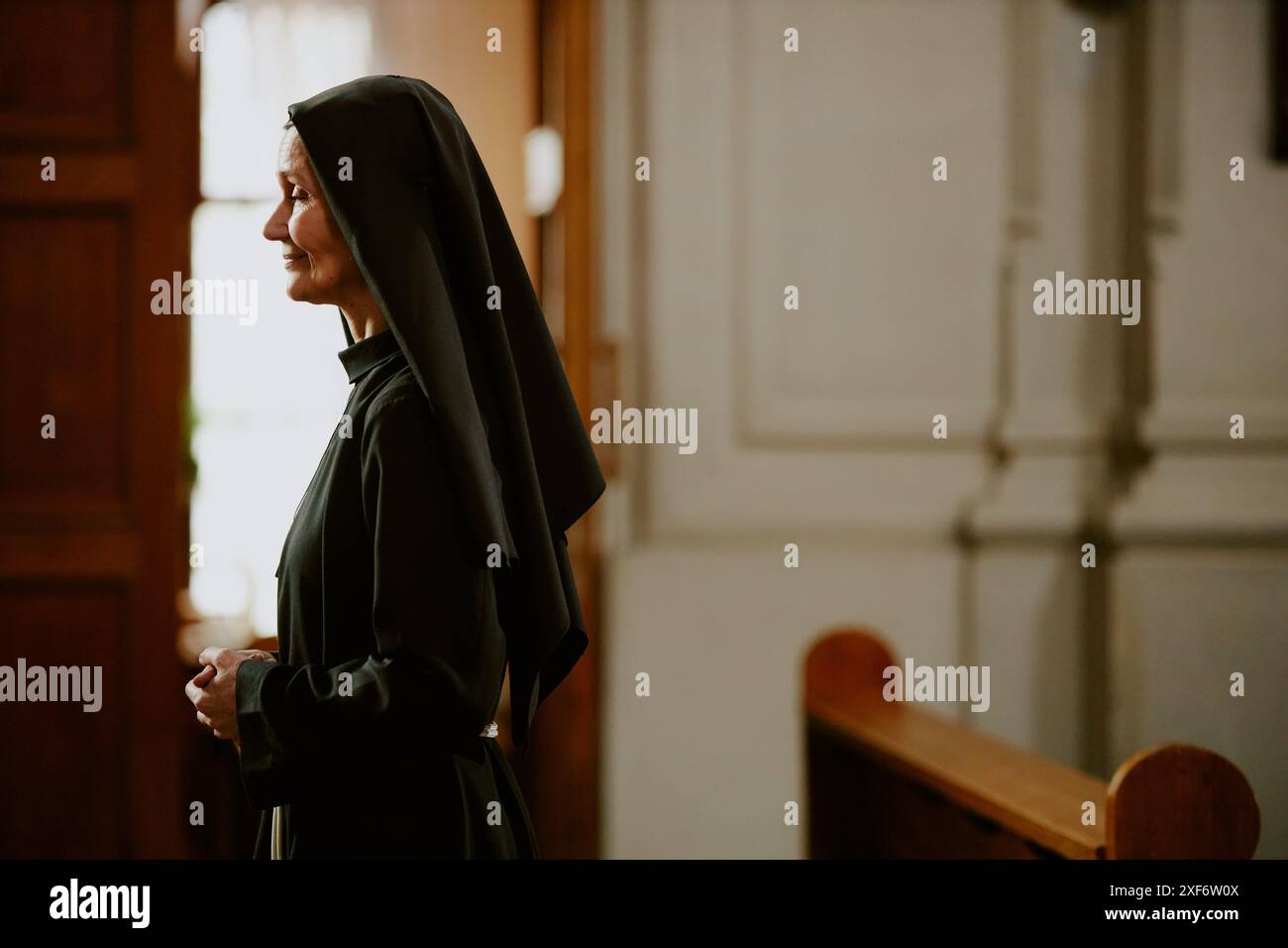 Medium side view shot of mature Caucasian nun wearing black religious ...