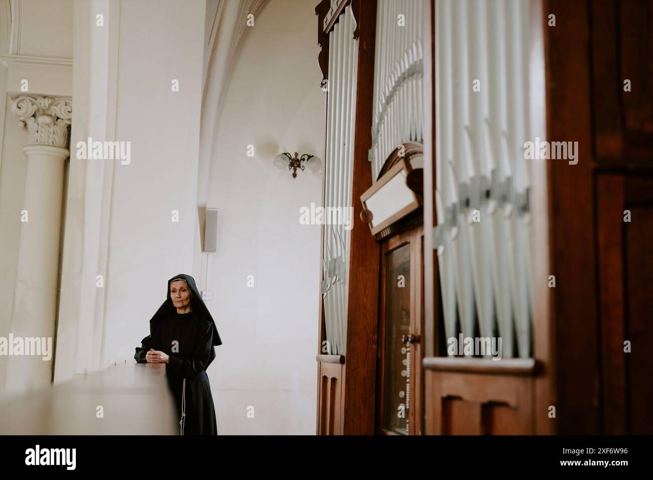 Pensive senior Caucasian nun standing near pipe organ in Catholic ...