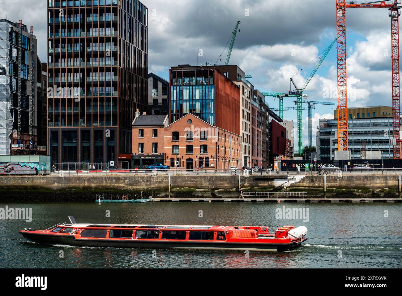 The bright red, glass-roofed tour boat, 'Spirit of Docklands' passing ...