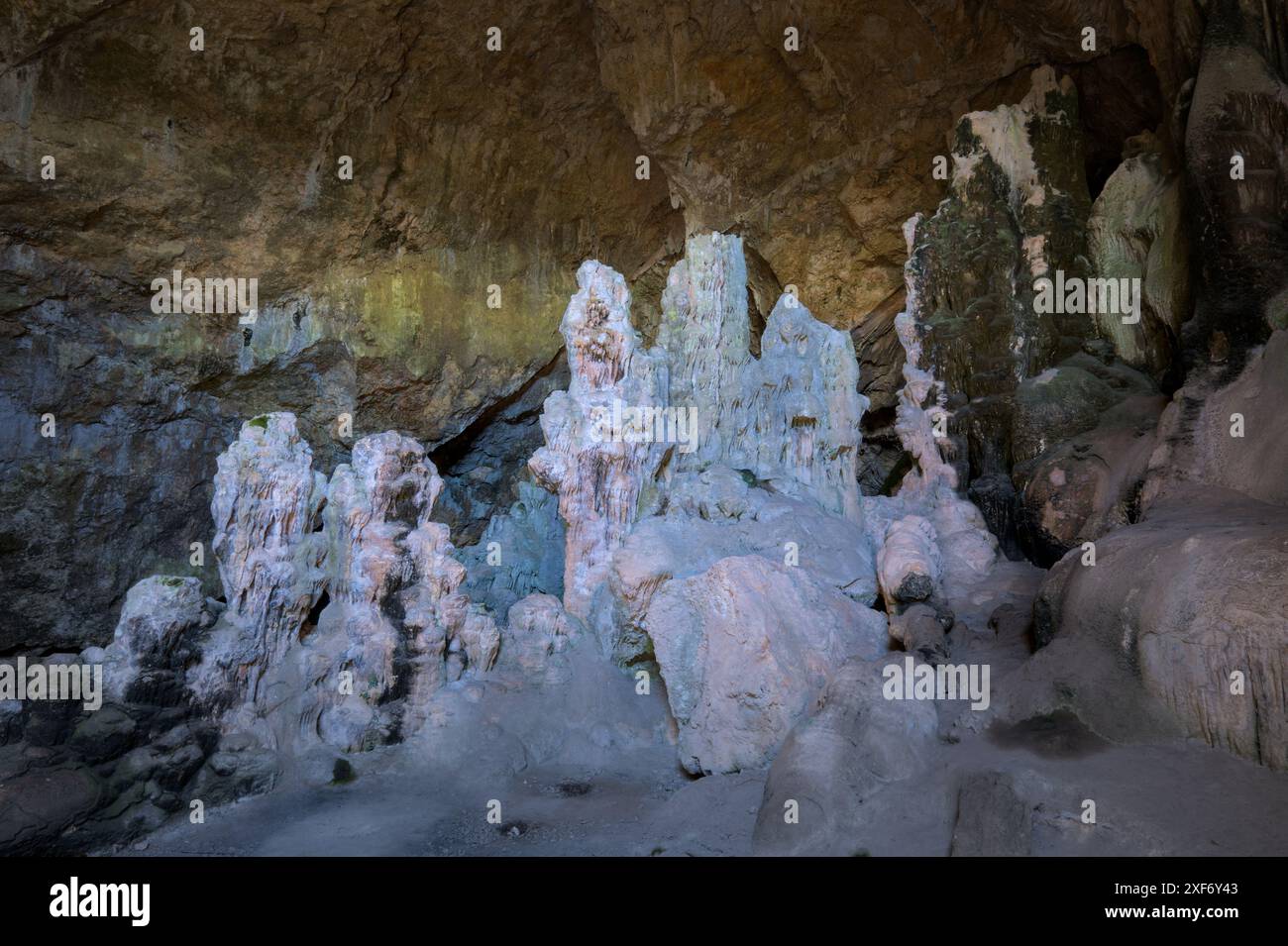 Cave interior with striking stalagmites and illuminated rock formations ...