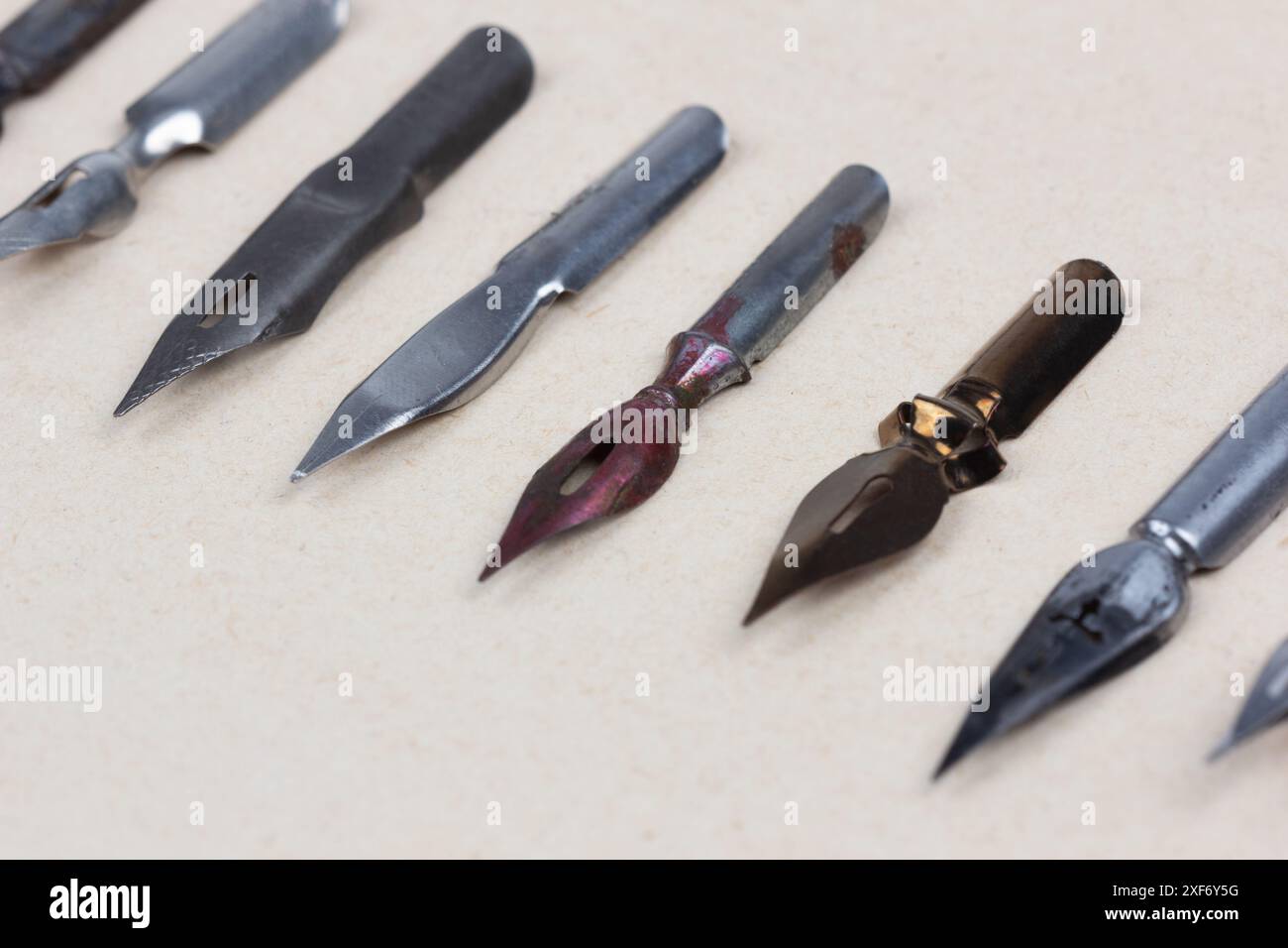 Metal nibs on an antique textured paper background Stock Photo - Alamy
