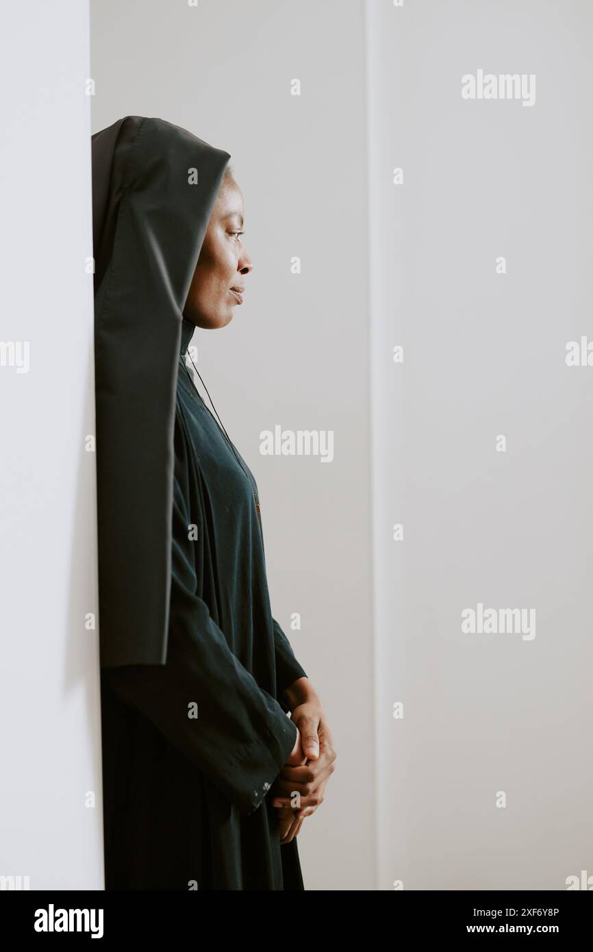 Vertical minimalistic shot of young African American Catholic nun ...