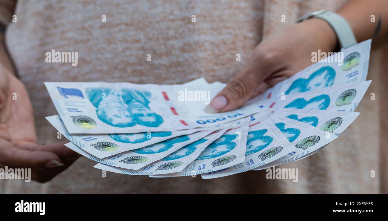 Ten thousand Argentine peso bills 2024. Woman holds 100,000 Argentine ...