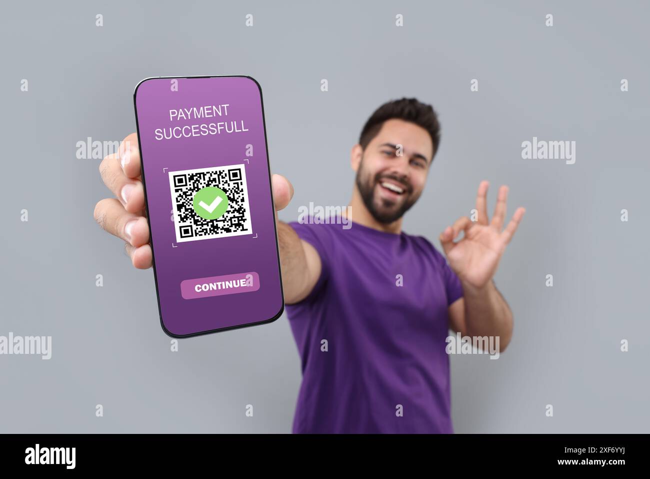 Happy man showing Ok gesture and mobile phone with online payment ...