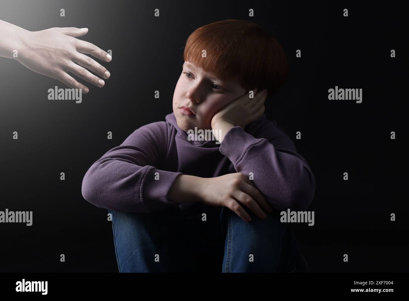 Sad little child looking at outstretched man's hand in darkness. Trust ...